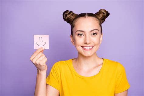최고의 주말 분위기를 표현하는 미소 그림과 함께 종이 스티커를 들고 예쁜 아가씨의 클로즈업 사진 노란색 T 셔츠 고립 파스텔