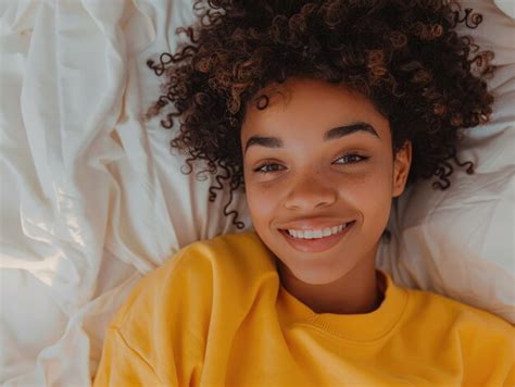 Premium Photo A Curly Haired Girl Lying In Bed Looking At The Camera