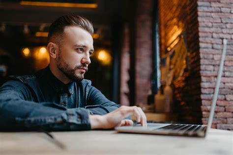 Premium Photo Young Male Programmer Working At A Laptop In A Coffee Shop