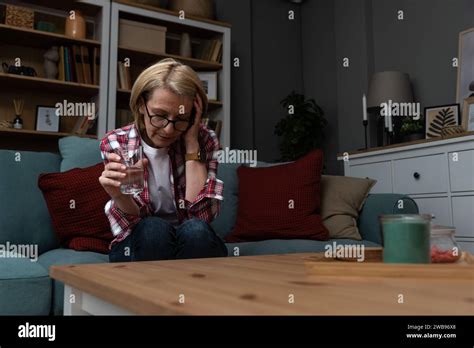 Elderly Senior Woman Sitting Alone In The Dark Of Her Apartment