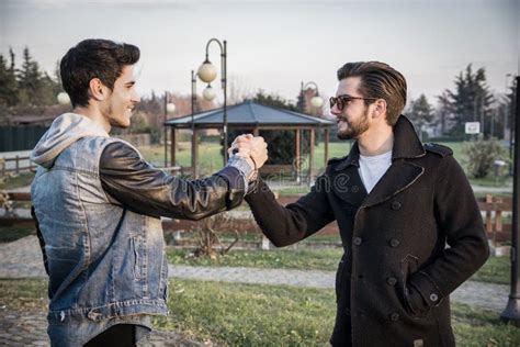 Dos Hombres Jovenes Hermosos Que Saludan En Un Parque Foto De Archivo
