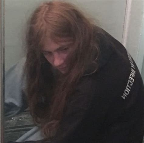 A Woman With Long Red Hair Is Looking At Her Cell Phone