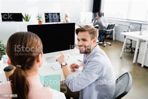 동료와 커피 근처 컴퓨터 모니터에 손가락으로 가리키는 웃는 사업가는 사무실에 가서 25 29세에 대한 스톡 사진 및 기타 이미지