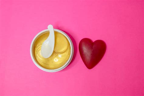 얼굴 마스크플라스틱 미용 항아리 분홍색 배경에 여성 얼굴 관리를위한 눈 아래 패치를 들어 올리는 황금 안티 안티 에이징 콜라겐 용기 스킨 케어 및 트리트먼트전용 화장품 0