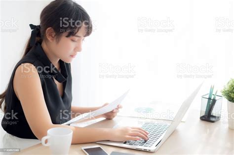 아름 다운 젊은 아시아 여자 사무실에서 랩톱 컴퓨터를 사용 하 여 작업 하 고 입력 사업가 찾고 그래프 다이어그램 분석 재무