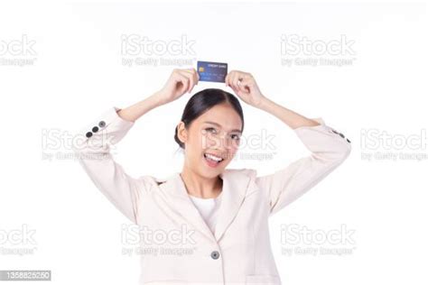은행 카드를 들고 양복을 입은 행복한 젊은 아시아 여성의 초상화 흰색 배경에 고립 된 신용 카드 비즈니스 온라인 쇼핑 개념