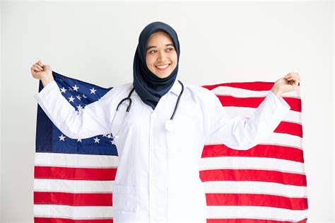 젊은 무슬림 여성 교환 학생 장학금 착용 미국 국기 위에 흰색 배경 개념 에 대한 히잡 소녀 이슬람 종교 아시아 행복 연합 단계 독립적 인 날 문화 개성 개념에 대한 스톡