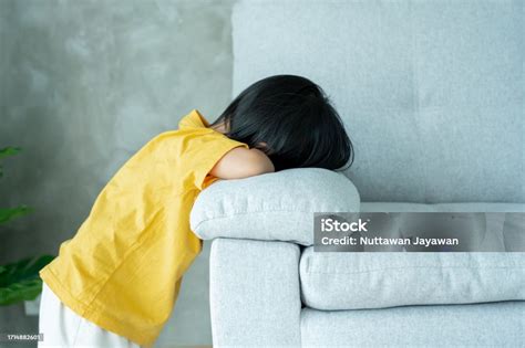 소파 뒤에 서서 숨바꼭질을 하는 어린 아시아 아이들 집에서 즐거운 시간을 보내는 사랑스러운 아이 행복한 가족은 아이들 활동 학습