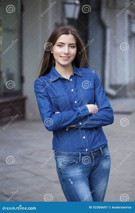Portrait Of A Beautiful Young Woman In A Blue Jeans Shirt On The Stock