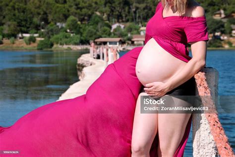 아름 다운 임신한 여자와 숙 녀 포옹 이며 자연 환경에 서 있는 그녀의 임신 배꼽 잡고 아기를 기다리고 있습니다 엄마 손 배