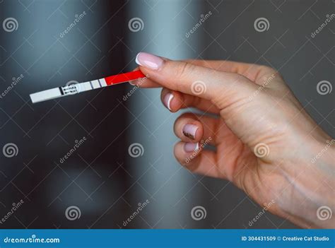Woman Hand Holding Positive Pregnancy Test With Two Lines On It