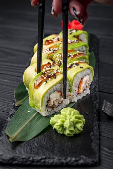 Sushi Roll With Smoked Eel Unagi Covered By Avocado And Sesame Seeds