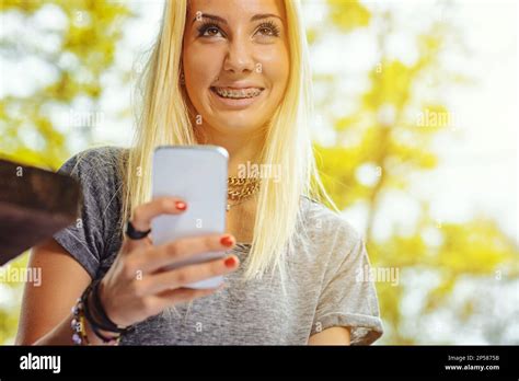 Beautiful Blond Girl In An Outdoor Forest Or Public Park On A Sunny Day