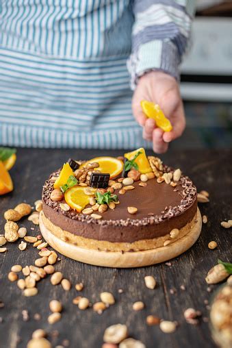 과자는 땅콩과 오렌지와 민트 잎 초콜릿 케이크를 장식 합니다 채식주의자를 위한 건강 한 생 디저트 감귤류 과일에 대한 스톡 사진 및 기타 이미지 Istock