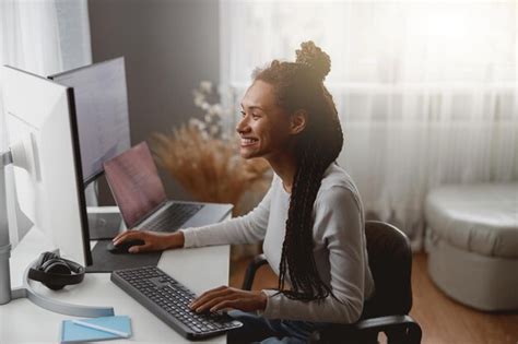 Premium Photo Smiled Cheerful Female Web Expert Sitting At Desk In Living Room Coding On Computer