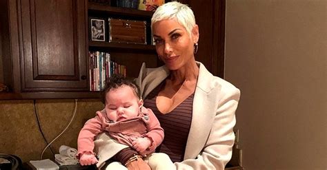 Nicole Murphy Cuddles Her Adorable Granddaughter Evie By The Christmas Tree In A New Photo