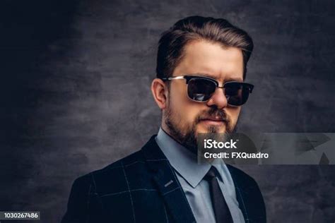 수염과 헤어스타일와 잘생긴 세련 된 중 년 남자의 클로즈업 초상화는 우아한 정장 양복과 선글라스 입고 스튜디오에서 질감 어두운 배경에 고립 고풍스런에 대한 스톡 사진 및