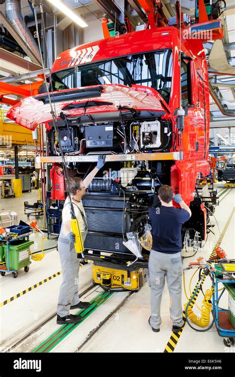 Employees Assembling The Chassis Engine And Gearbox To The Cab At Man