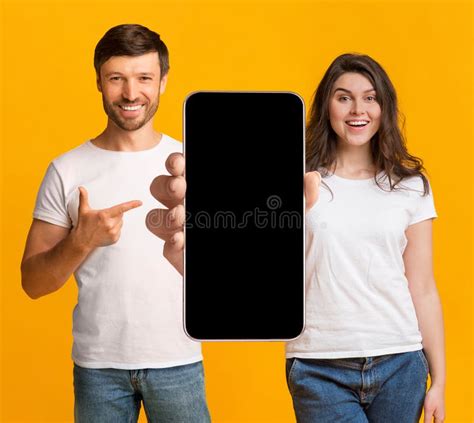 Online Offer Happy Millennial Couple Demonstrating Big Smartphone With