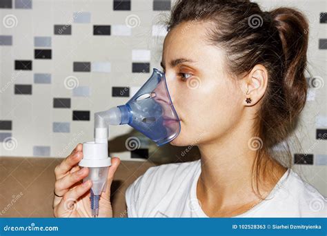 Woman Breathes Into An Inhaler Mask Closeup Treatment Of Coughing With
