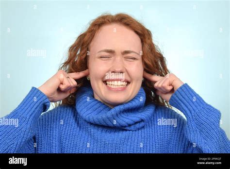 Cute Red Haired Curly Woman Covered Her Ears With Her Fingers And