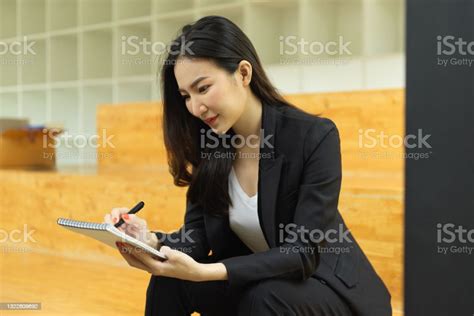 계단 케이스에 앉아있는 동안 노트북에 쓰는 검은 양복을 입은 사업가의 측면 보기 초상화 20 24세에 대한 스톡 사진 및 기타