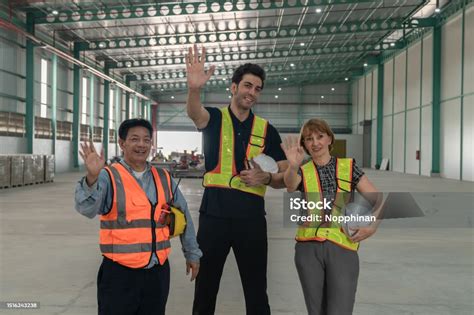 안전 조끼를 입은 공장 엔지니어가 창고에 서서 손을 흔든다 개발에 대한 스톡 사진 및 기타 이미지 개발 건축가 검사자