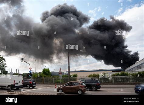 A huge stream of dark smoke from a factory in a German city in daylight ...