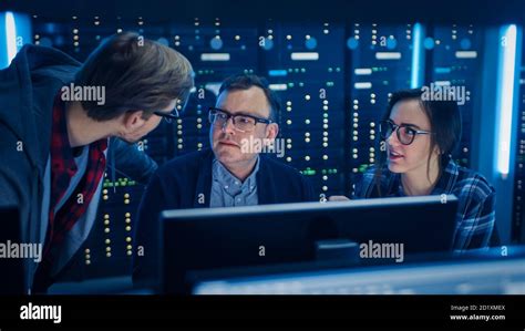 Male And Female IT Engineers Programmers Having Discussion About Coding On Desktop Computers