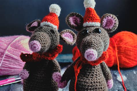 크리스마스 모자와 파란색 배경에 밝은 원사 Clews 근처에 서 있는 사랑스러운 수제 Amigurumi 쥐 새해 2020 개념