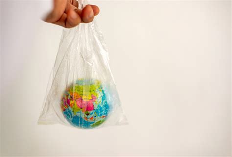 여자의 손은 비닐 봉지에 지구를 보유하고 있다 사회 광고를위한 빈 칸에는 비문에 대한 장소가있다 플라스틱 파편에 의한 오염의 개념 환경의 날 Referendum에 대한 스톡