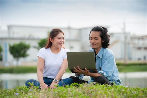 Premium Photo Man And Woman Using Laptop Computer Sitting Outdoor