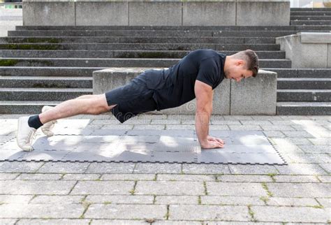Young Man Doing A Triangle Push Up Or Diamond Push Up Outdoors On An
