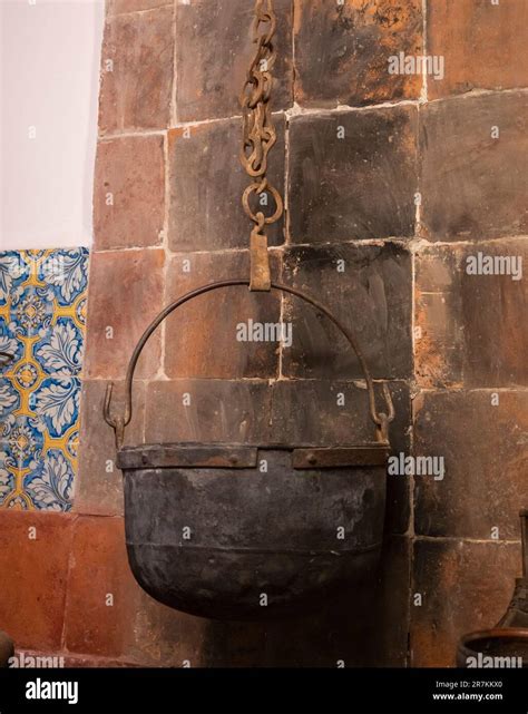 A Vintage Large Cooking Pot Hung Up With A Metal Chain In A Museum