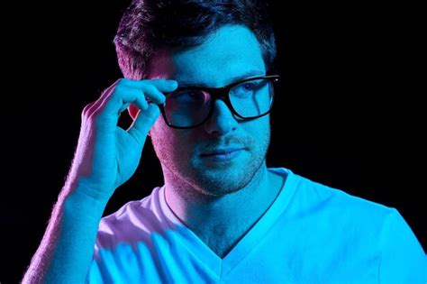 Premium Photo Man In Glasses Over Neon Lights In Dark Room