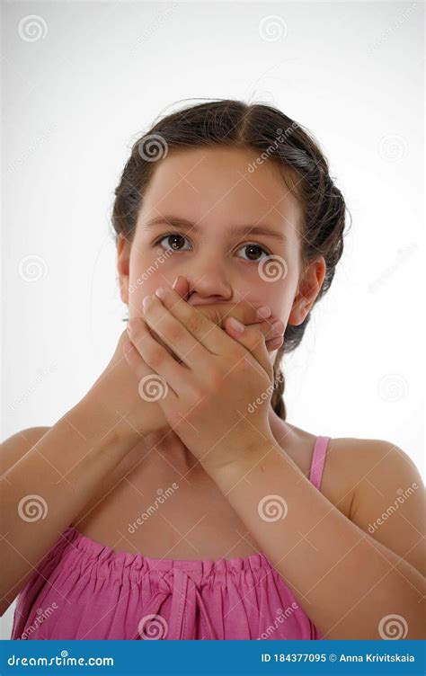 Young Girl In Pink Covering Her Mouth With Her Hands Stock Image
