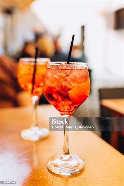 메스칼 네그로니 스프리츠 칵테일 야외에 얼음 조각이 있는 테이블을 기반으로 한 알코올 음료 오렌지 슬라이스와 짚을 곁들인