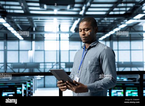 Engineer In Data Center With Tablet Automating Routine Maintenance