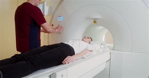 The Doctor Starts The Mri Machine From The Control Panel A Young