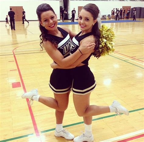 Two Cheerleaders Hugging Each Other On A Basketball Court