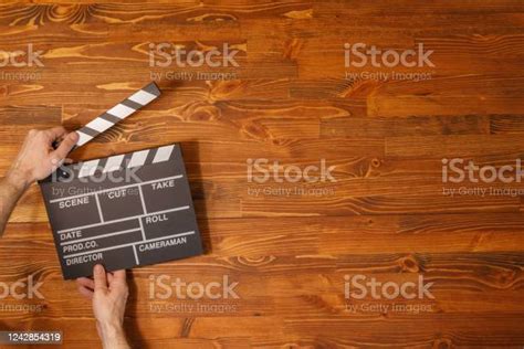 남자는 손에 검은 클래퍼 보드를 들고있다 나무 배경 위에 영화 제작 클래퍼 보드 맨 위 보기입니다 공간을 복사합니다 감독에 대한 스톡 사진 및 기타 이미지 Istock