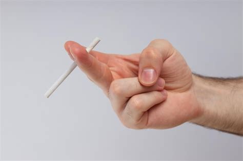 Free Photo A Cigarette In A Mans Hand On A Light Background