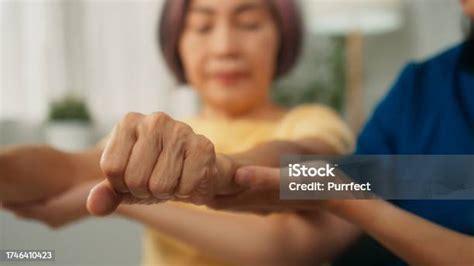 노인 환자의 부상당한 팔과 손을 검사하는 여성 물리치료사 의사 간병인 간호사와 함께 재활 치료를 하는 노인 할머니 2명에 대한