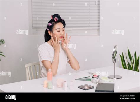 Pretty Asian Woman Making Face Lifting Massage Sitting At Table In