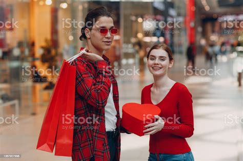 남자는 발렌타인 데이에 그의 여자 친구에게 하트 모양의 상자를 제공합니다 쇼핑몰에서 젊은 부부 18 19세에 대한 스톡 사진 및 기타 이미지 Istock