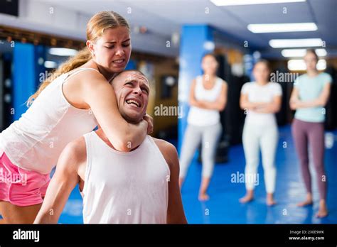 Girl Performing Rear Choke Hold While Sparring With Male Opponent Stock