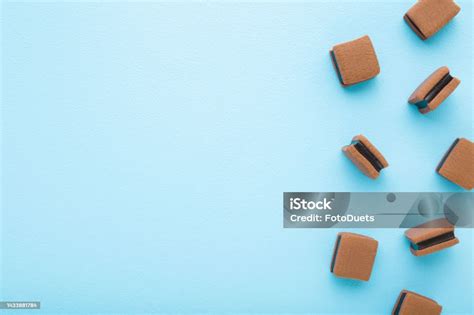 밝은 파란색 테이블 배경에 다크 초콜릿을 곁들인 브라운 젤리 구미 사탕 파스텔 색상 달콤한 스낵 근접 촬영 텍스트의 빈