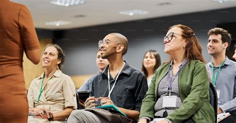 컨벤션 센터에서 열린 컨퍼런스 행사에서 연사를 경청하는 다인종 사업가 그룹 사진 Unsplash의 발표자 이미지