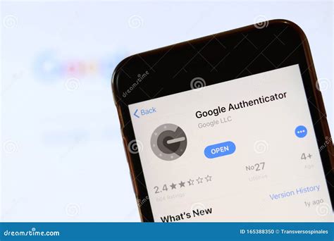 Phone With Google Authenticator Icon On Screen Close Up With Blur Website On Laptop Los Angeles
