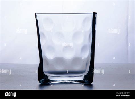 Glass Broken In Two Halves With An Ice Cube Photographed On White
